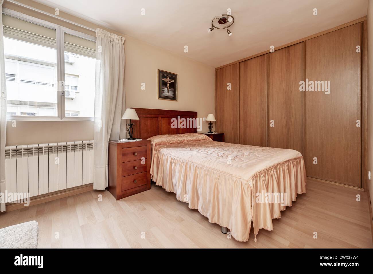 bedroom with double bed with salmon-colored satin duvet and built-in ...