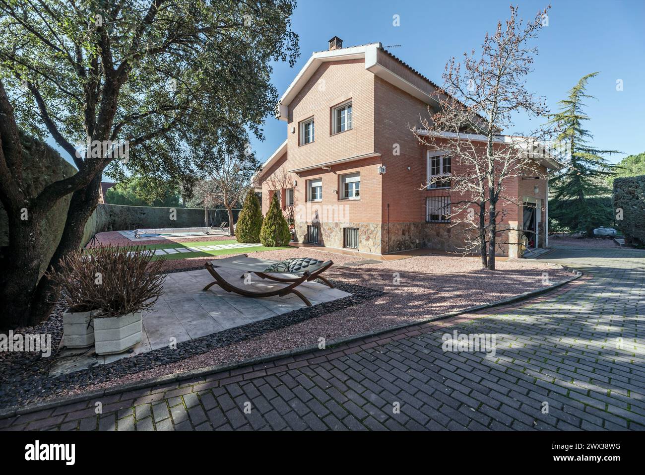 Detached chalet with gravel and grass floor, trees, plants and hedges ...