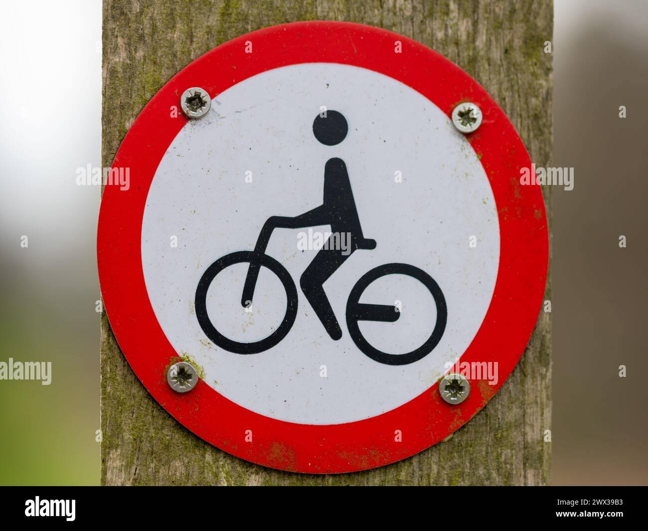 A ROUND PROHIBITION SIGN FOR CYCLING IN RED AND WHITE, PLACED ON A ...