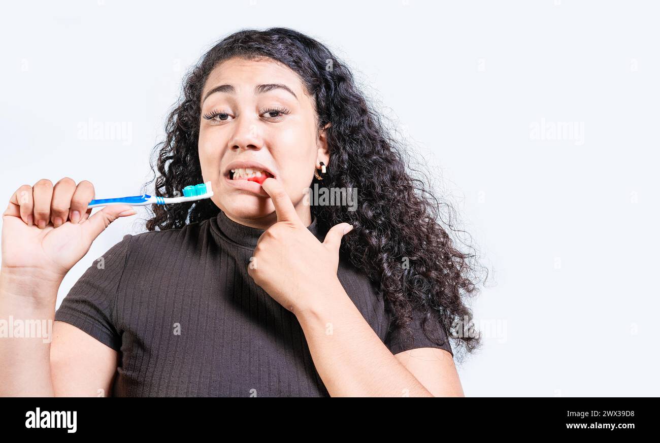 Young woman with gingivitis holding toothbrush isolated. Girl suffering ...