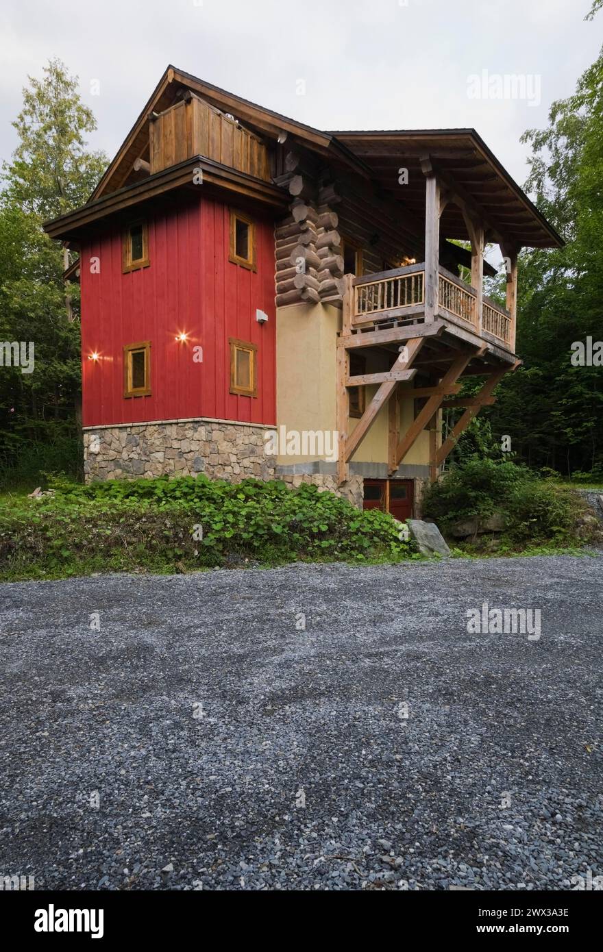 Rear view of illuminated three story Scandinavian hybrid style log ...