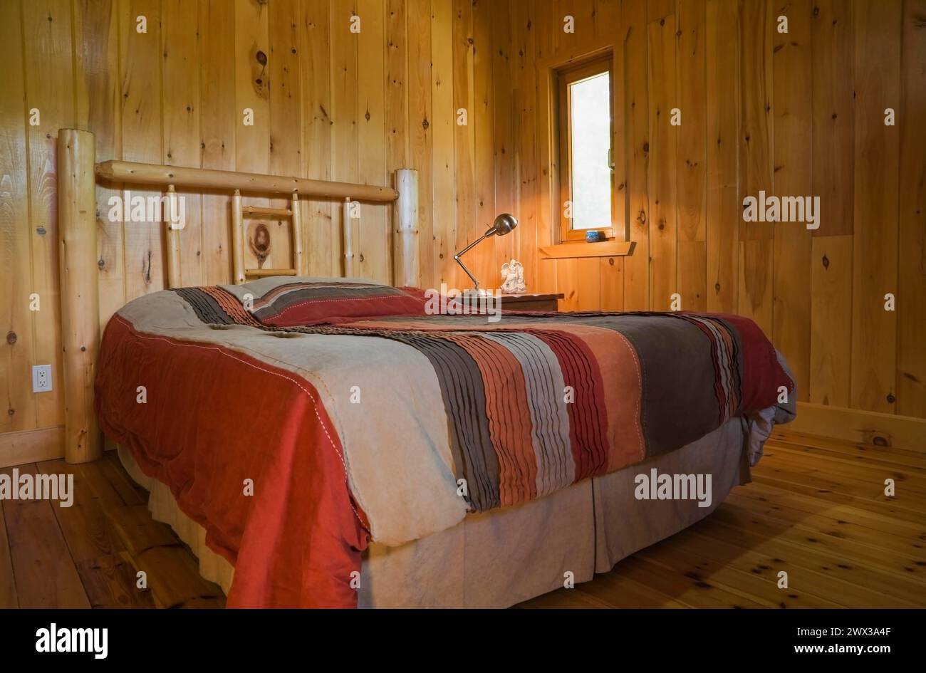 Queen size bed covered with colorful striped bedspread and rustic white ...