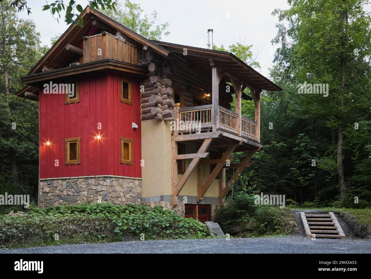 Rear view of illuminated three story Scandinavian hybrid style log ...
