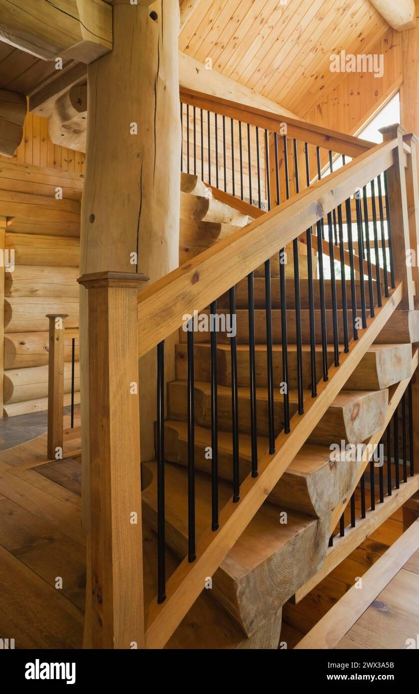 Twisting staircase with wooden and black wrought iron handrail and ...