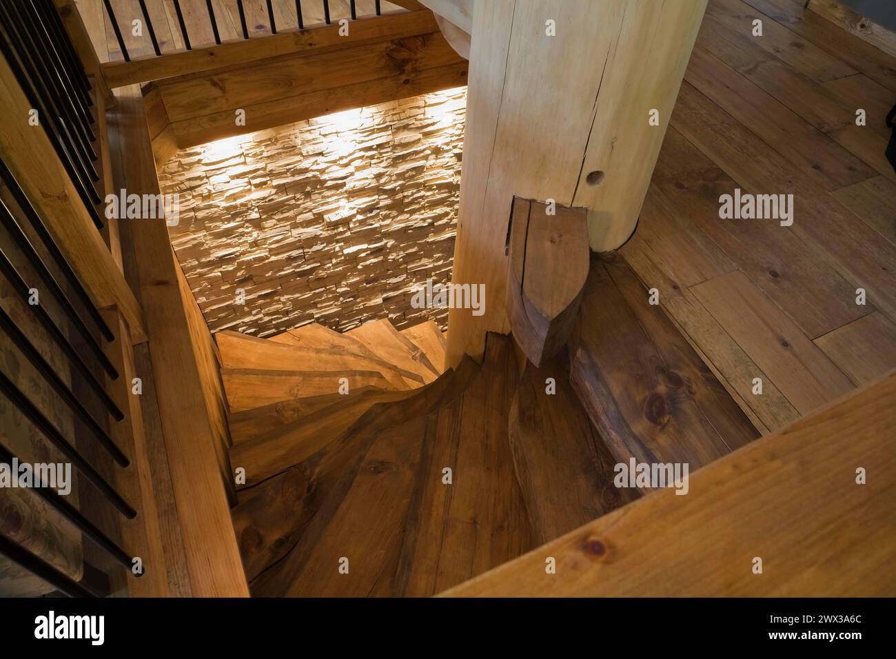 Wood and black wrought iron handrails surrounding steep twisting ...