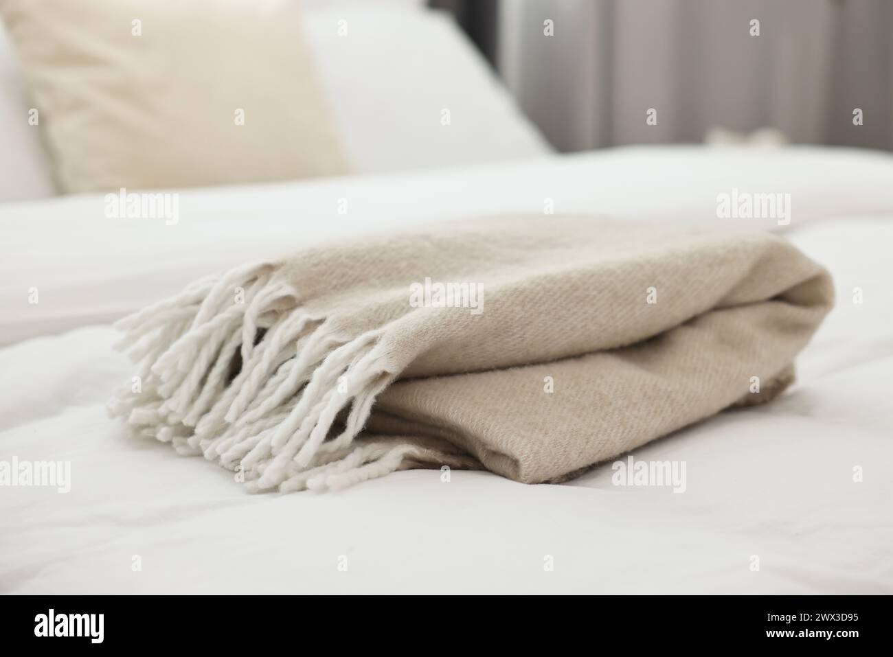 Soft beige plaid on bed in bedroom Stock Photo - Alamy