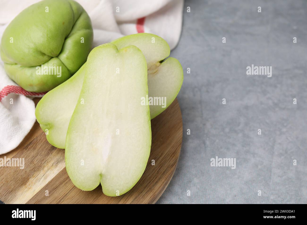 Cut and whole chayote on gray table, closeup. Space for text Stock ...