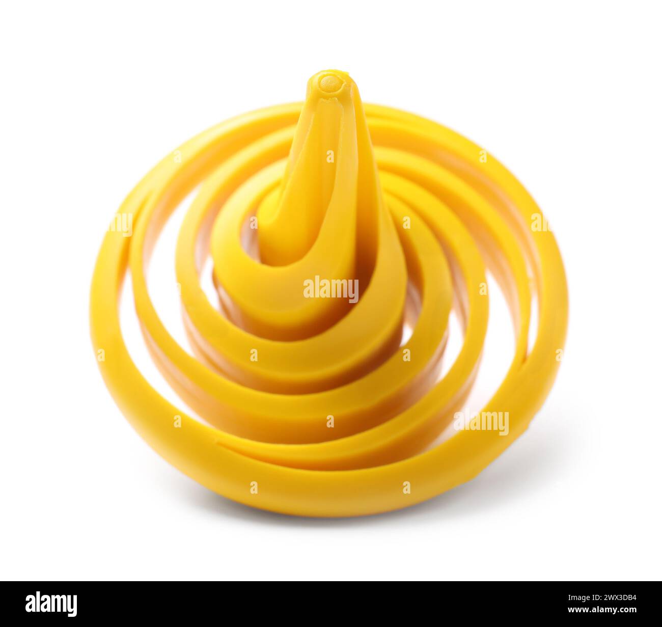 One yellow spinning top on white background Stock Photo - Alamy