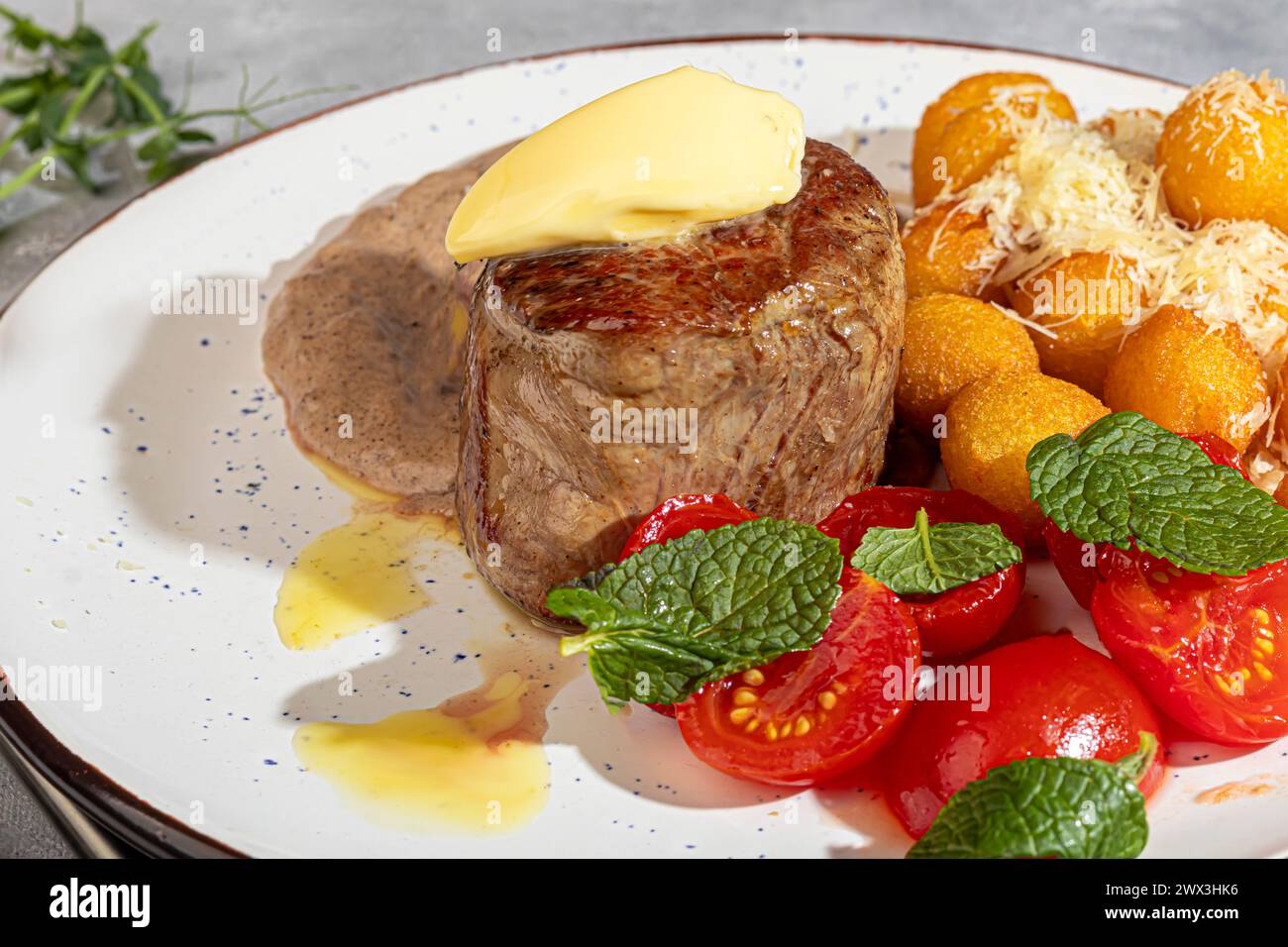 Beef medallion with potato balls and mushroom sauce, topped with a ...