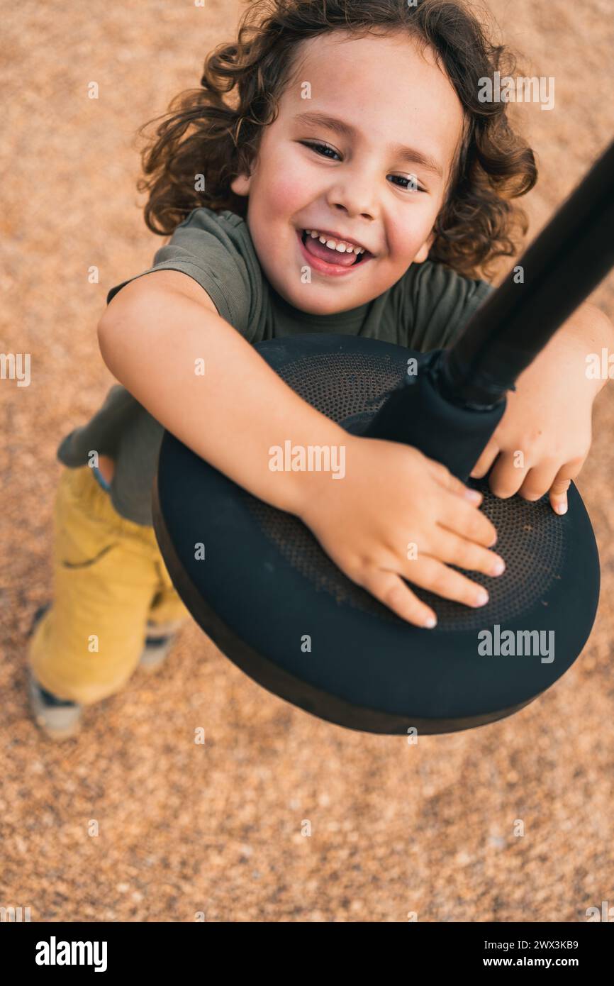 close up of happy little boy playing with zip line in playground ...