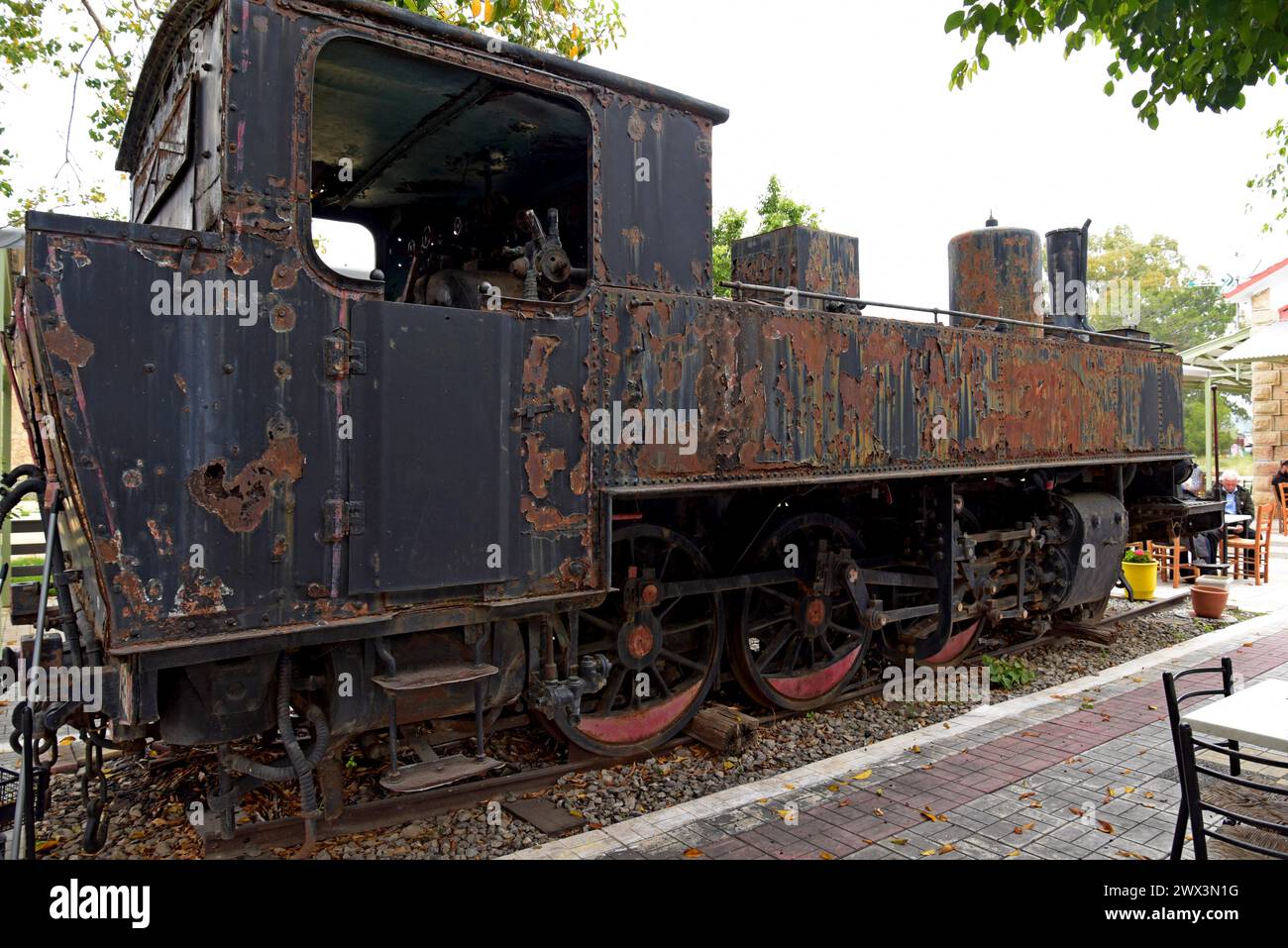 Rusty disused steam loco next to a cafe in the disused Kyparissia ...