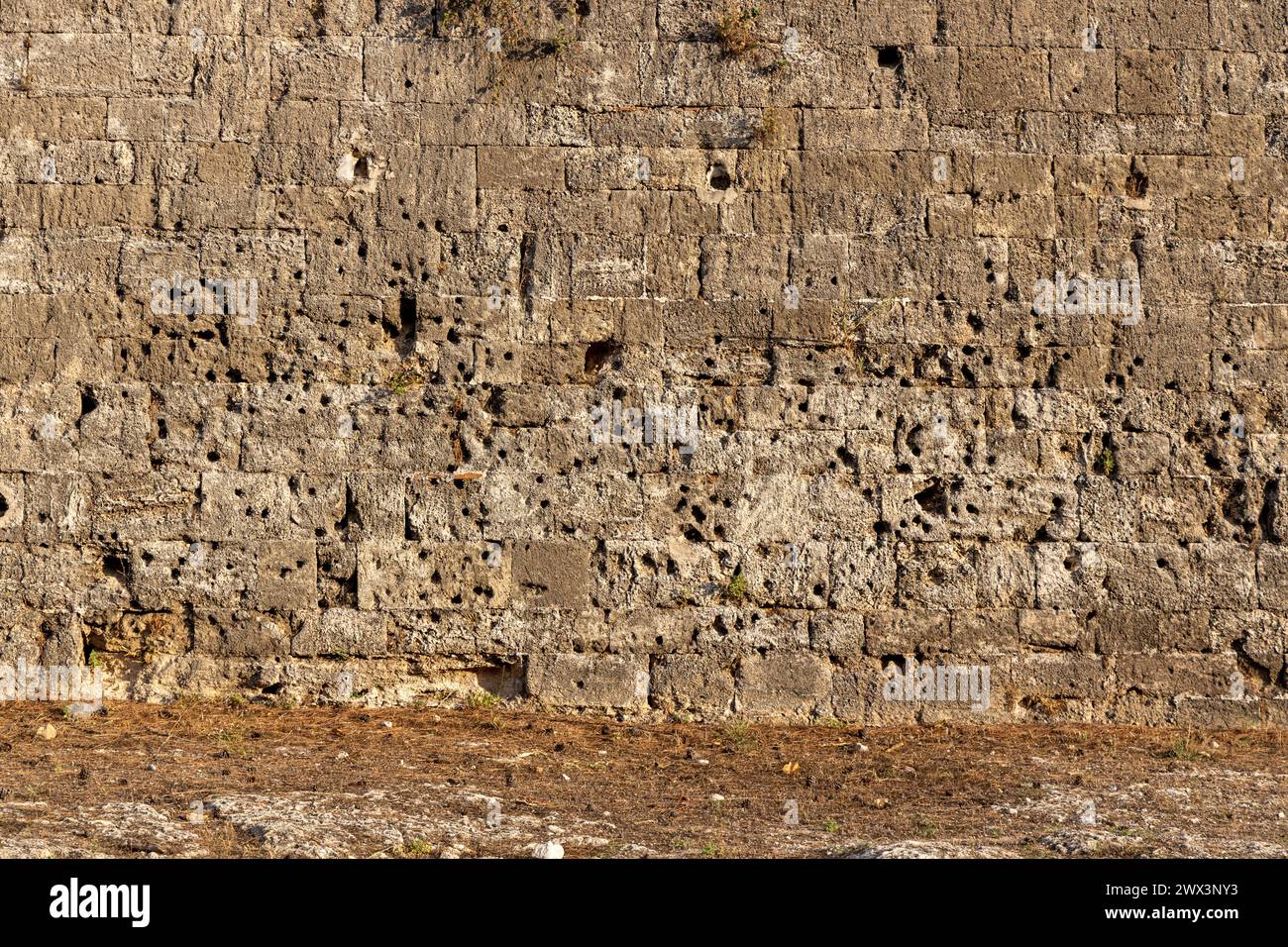 War damage, bullet holes in stone wall in the moat of old town Rhodes ...