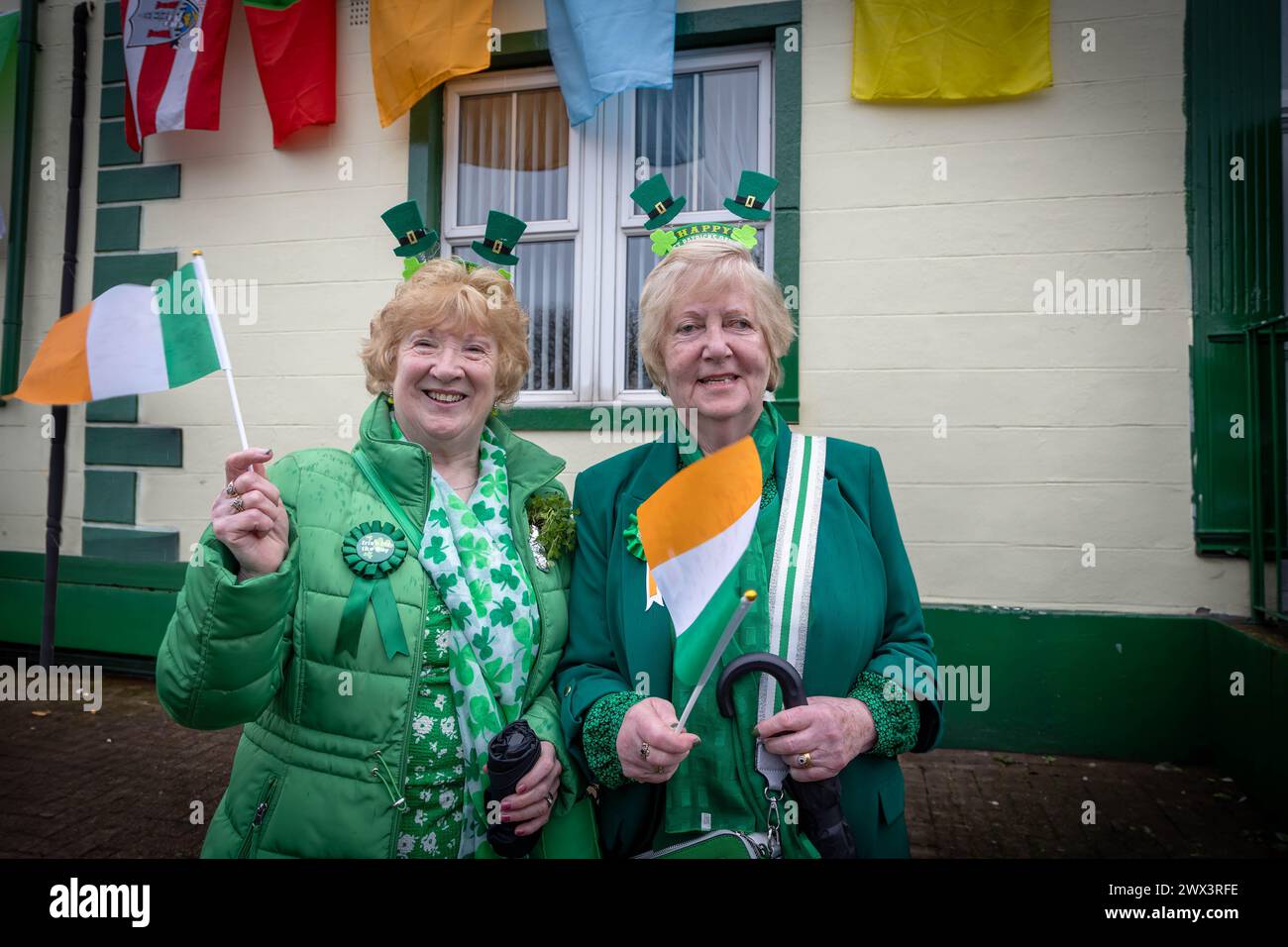 Two women wearing Happy St Patrick's Day bonce bopperswaving Irish ...