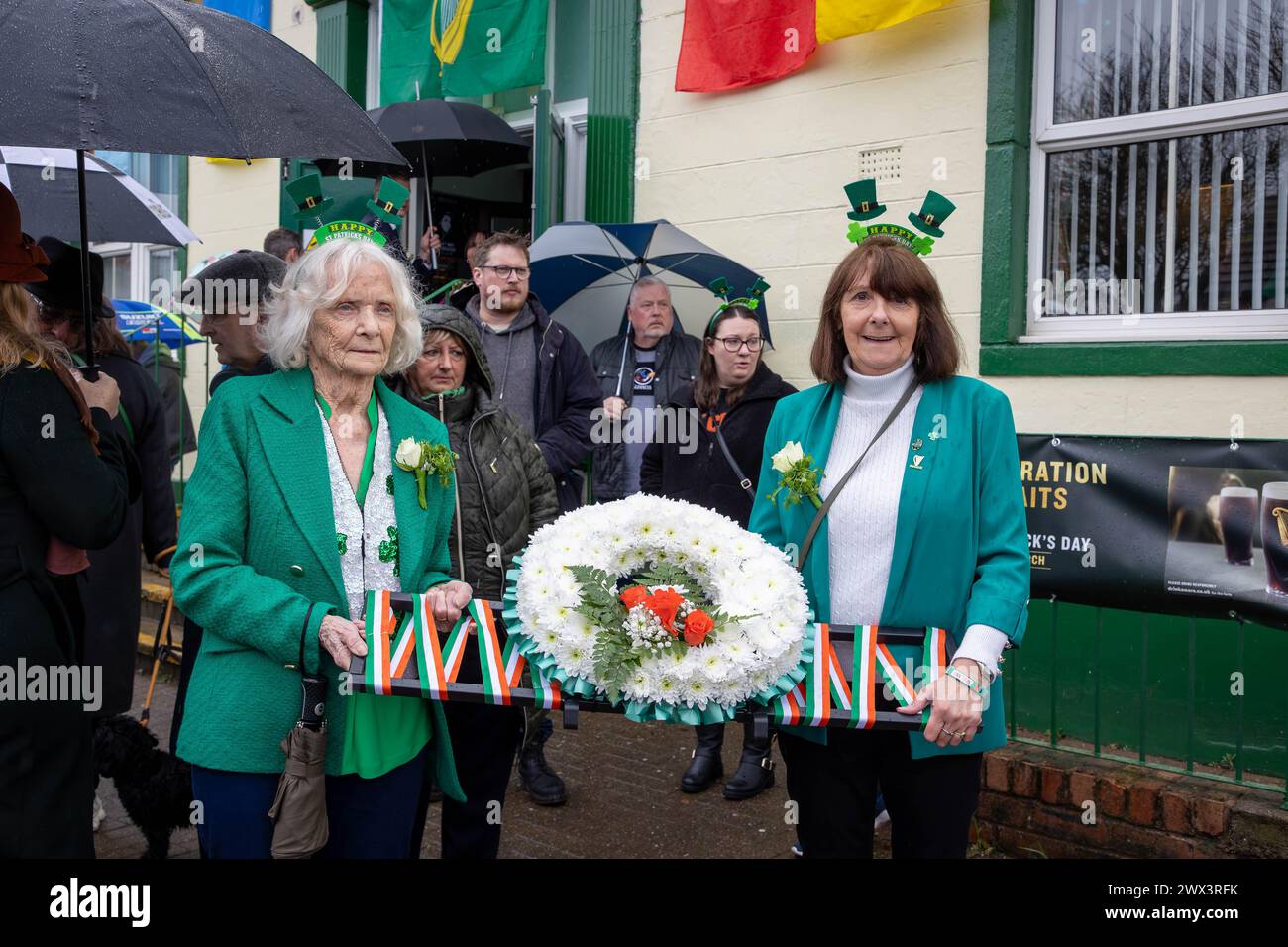 Two ladies carry an Irish wreath from outside Warrington Irish Club on ...