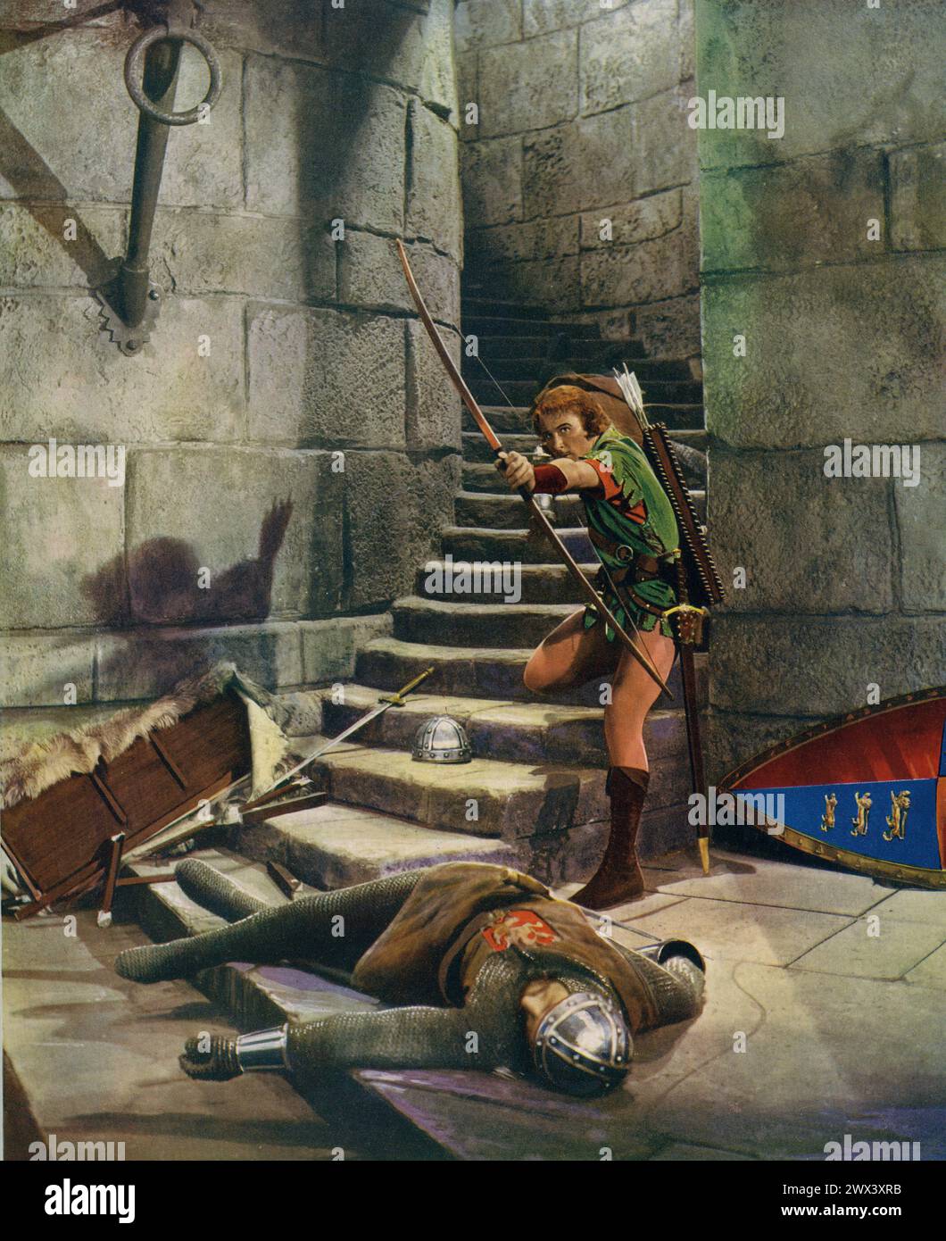 ERROL FLYNN as Robin Hood with bow and arrow making his escape from ...