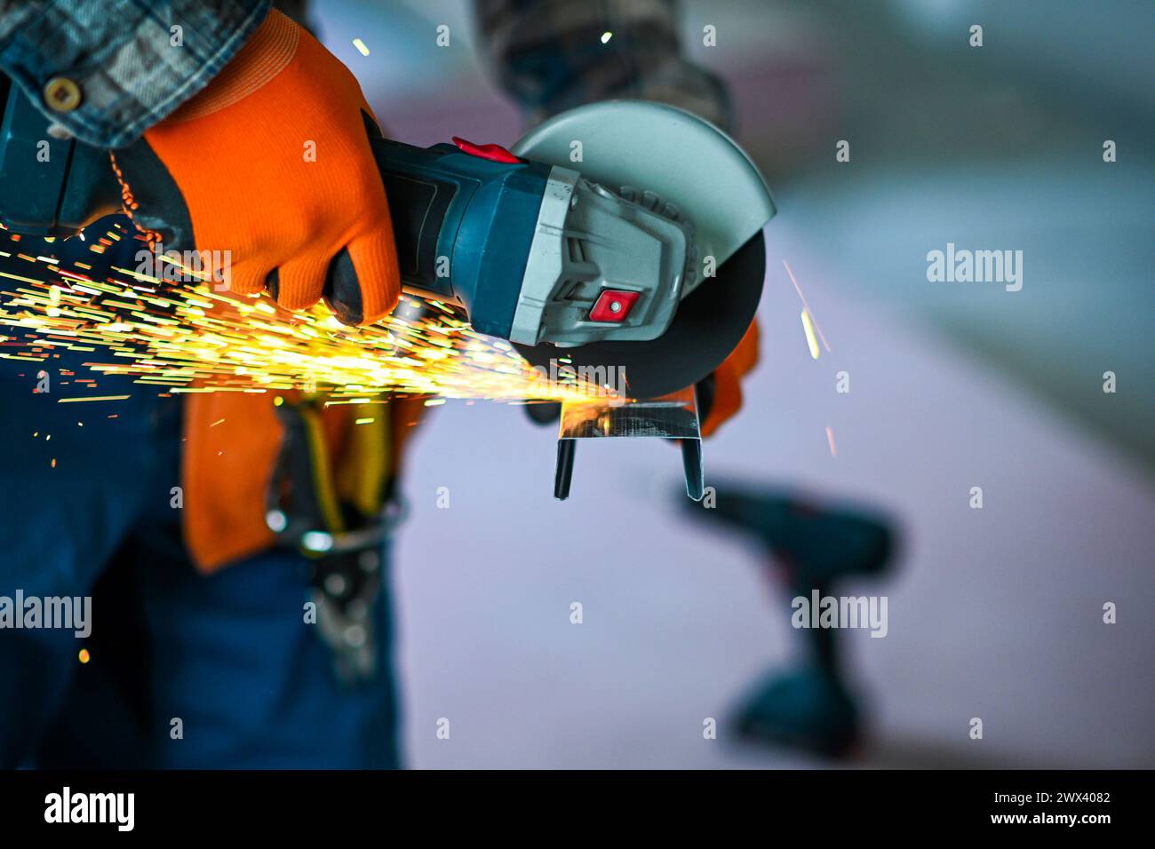 a worker saws a plasterboard profile using an angle grinder Stock Photo ...