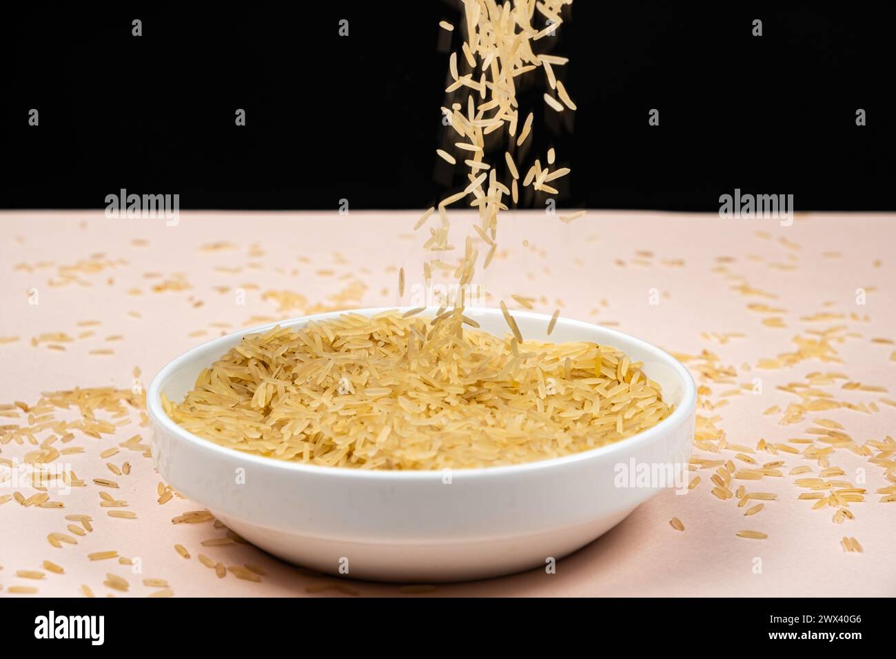 Long grain parboiled basmati rice pouring into the plate Stock Photo ...