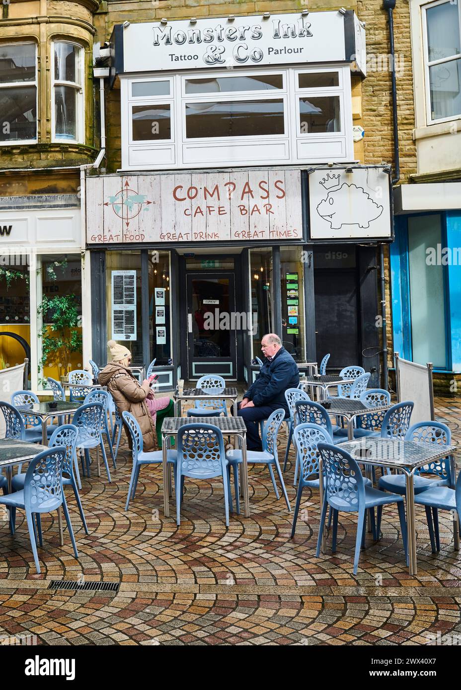 Couple sat at cafe outside table in the rain Stock Photo - Alamy
