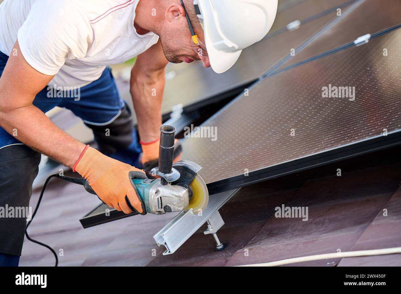 Worker installing or maintaining photovoltaic solar panel system on ...