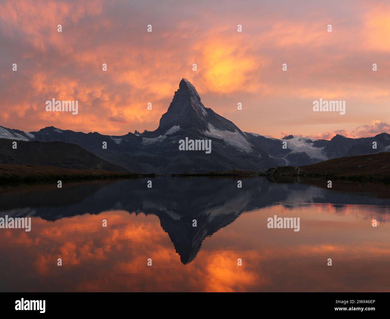 Sunset with dramatic alpenglow at the high mountain lake Stellisee with ...