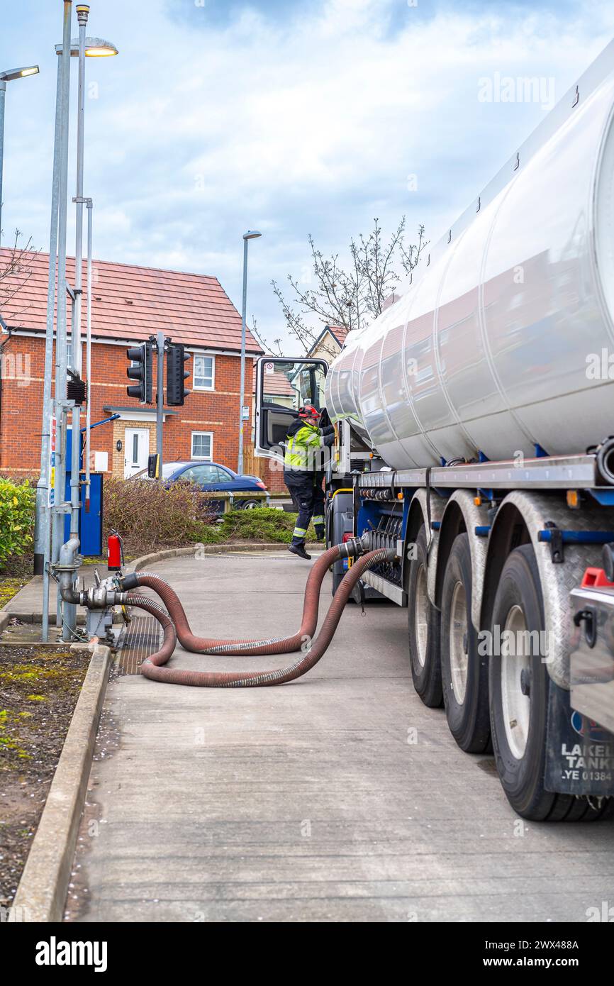 Close up side view of a petrol tanker refilling fuel tanks at a garage ...