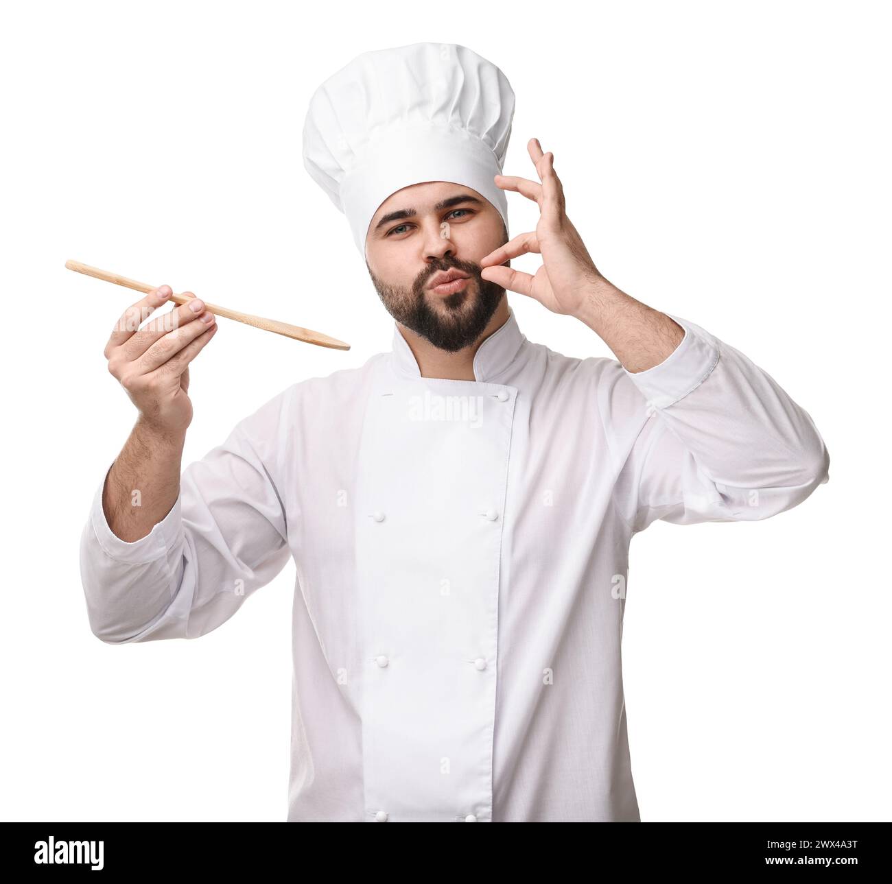 Young chef in uniform tasting something and showing perfect sign on ...