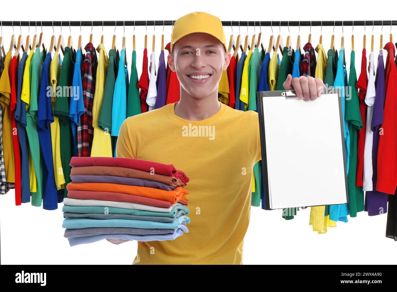 Dry-cleaning delivery. Happy courier holding folded clothes and ...