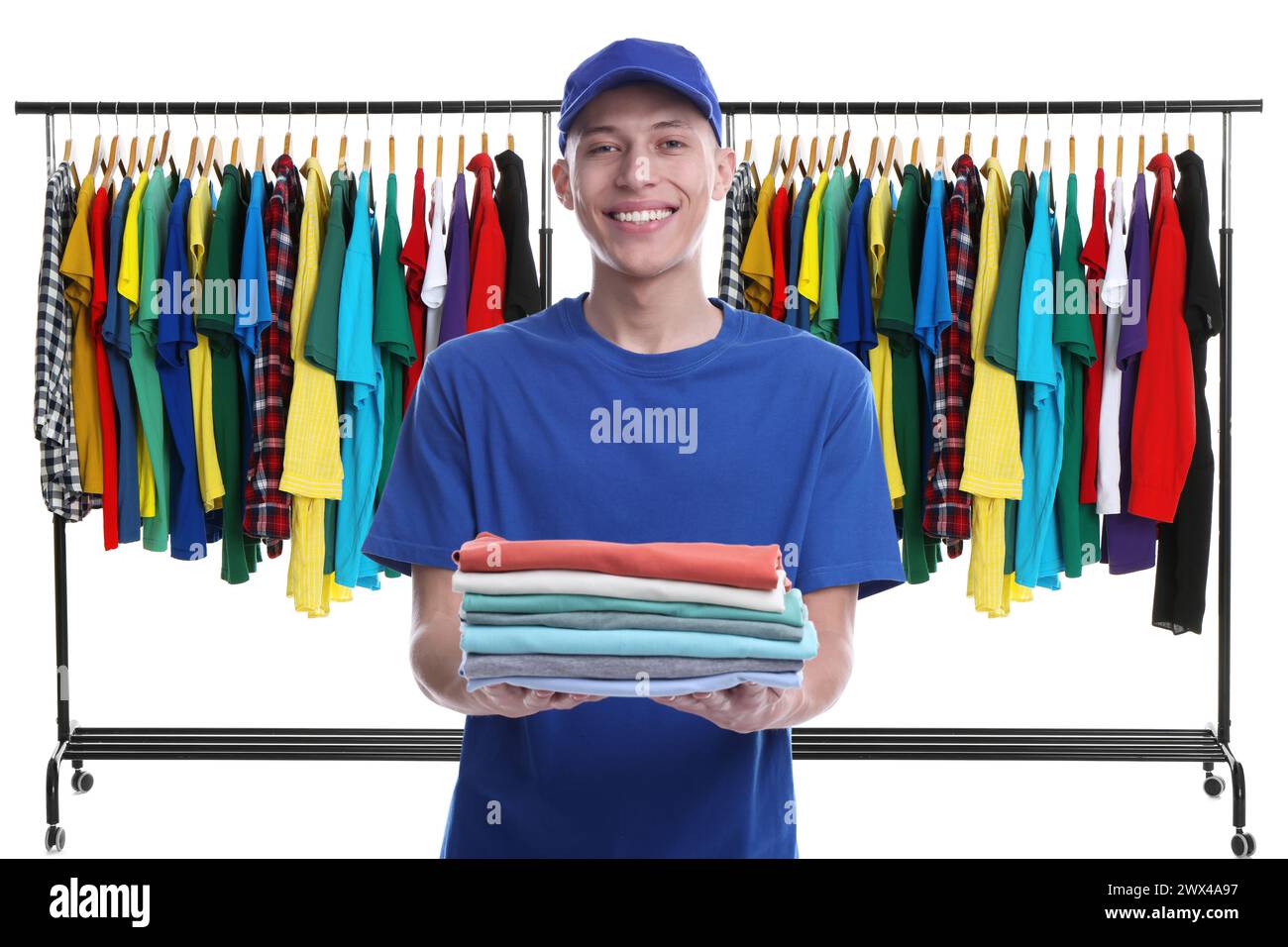 Dry-cleaning delivery. Happy courier holding folded clothes near ...