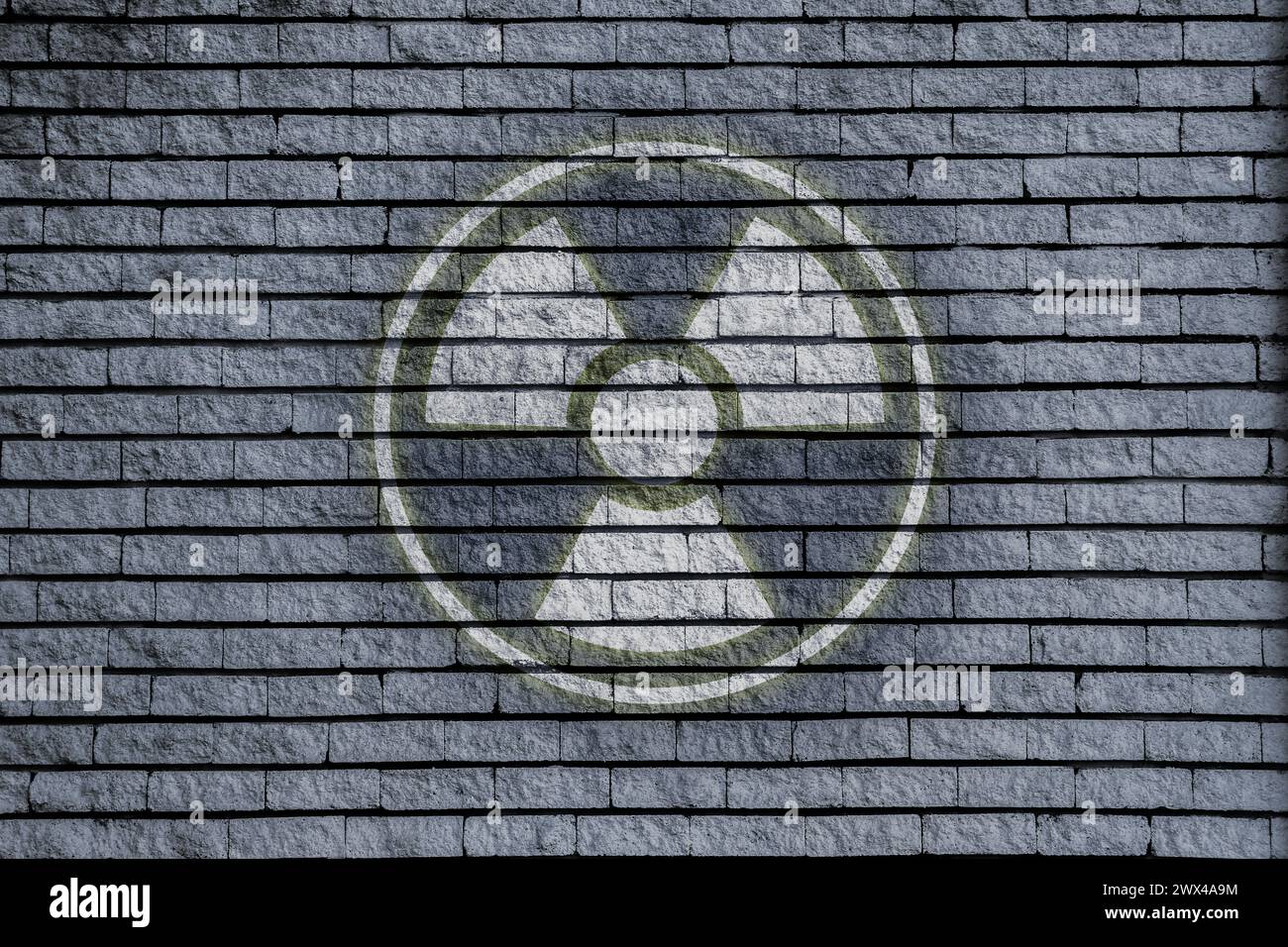Radioactive sign on grey brick wall. Hazard symbol Stock Photo - Alamy