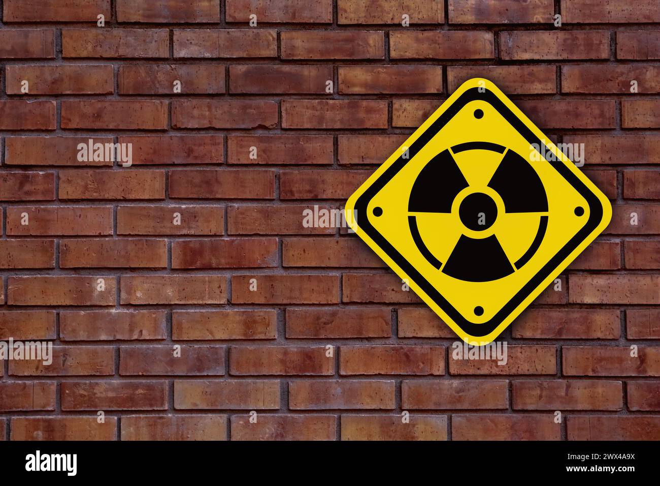 Radioactive sign on brick wall, space for text. Hazard symbol Stock ...
