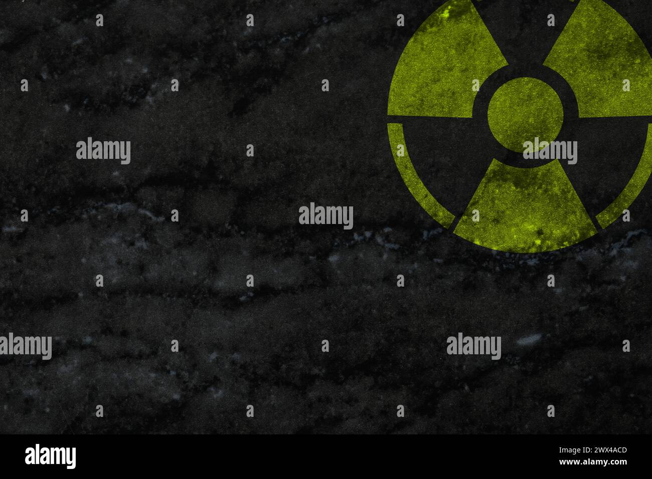 Radioactive sign on dark marble wall, space for text. Hazard symbol ...
