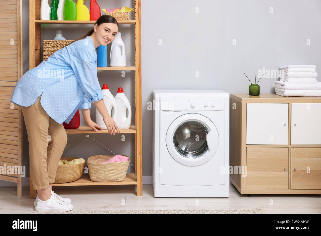 Beautiful woman in laundry room with washing machine Stock Photo - Alamy