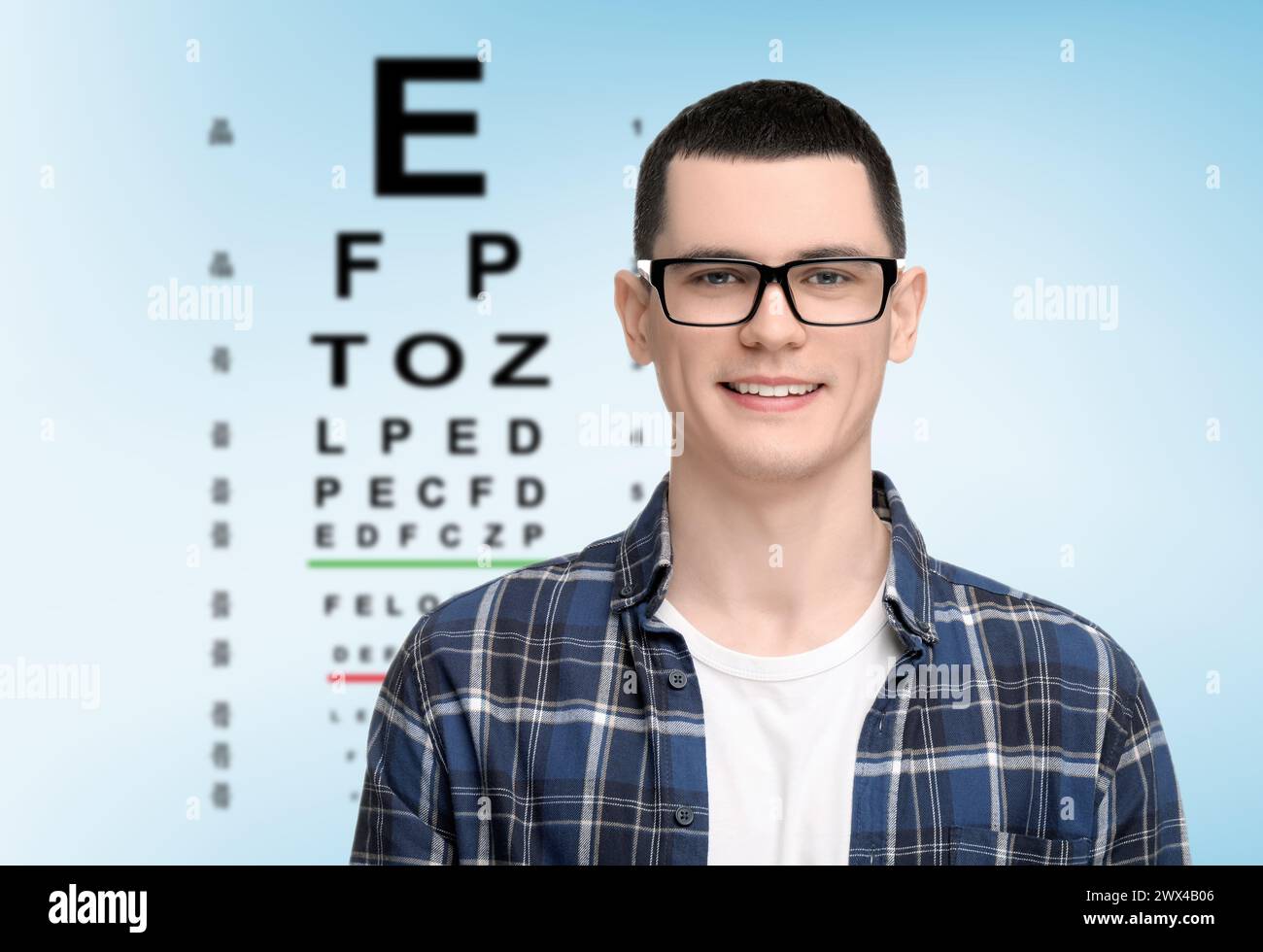 Vision test. Man in glasses and eye chart on light blue background ...