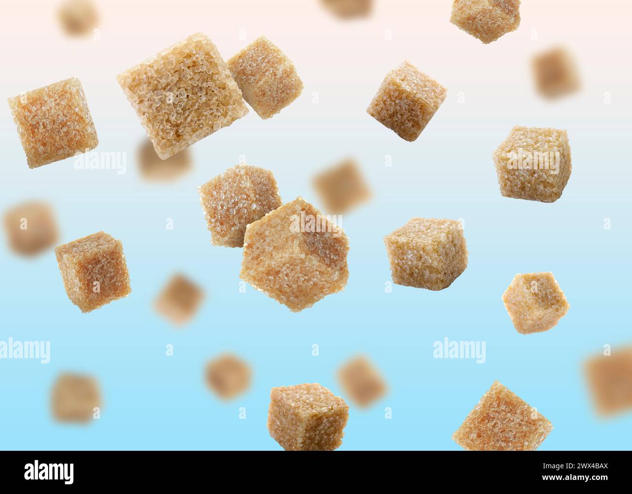Brown cane sugar cubes falling on light blue gradient background Stock ...