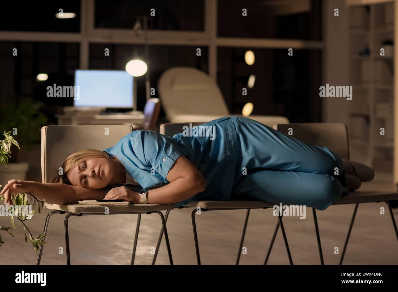 Female nurse sleeping on chairs at hospital in evening Stock Photo - Alamy