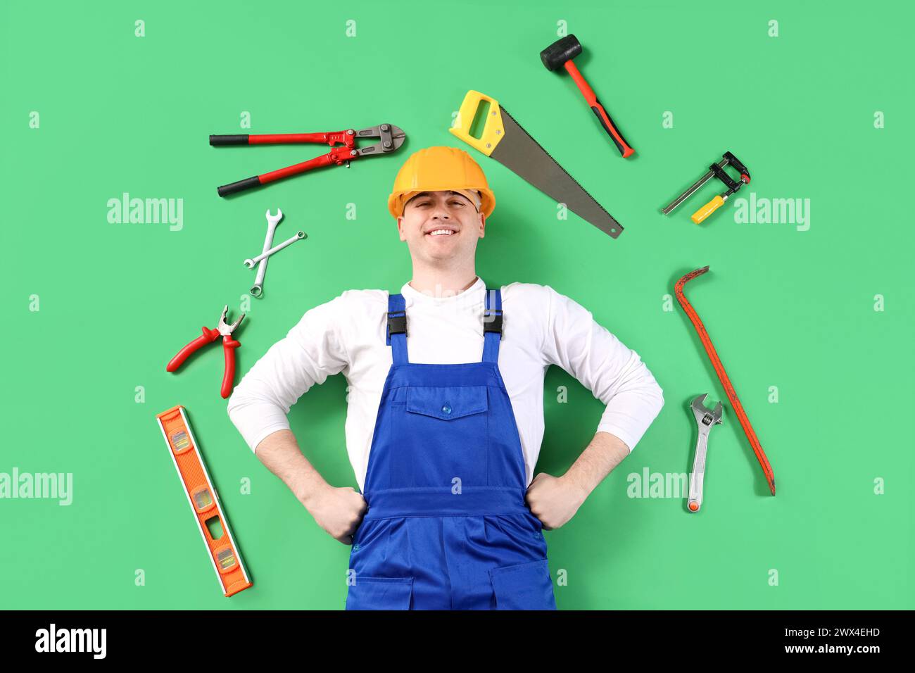 Male builder with work tools on green background, top view Stock Photo ...