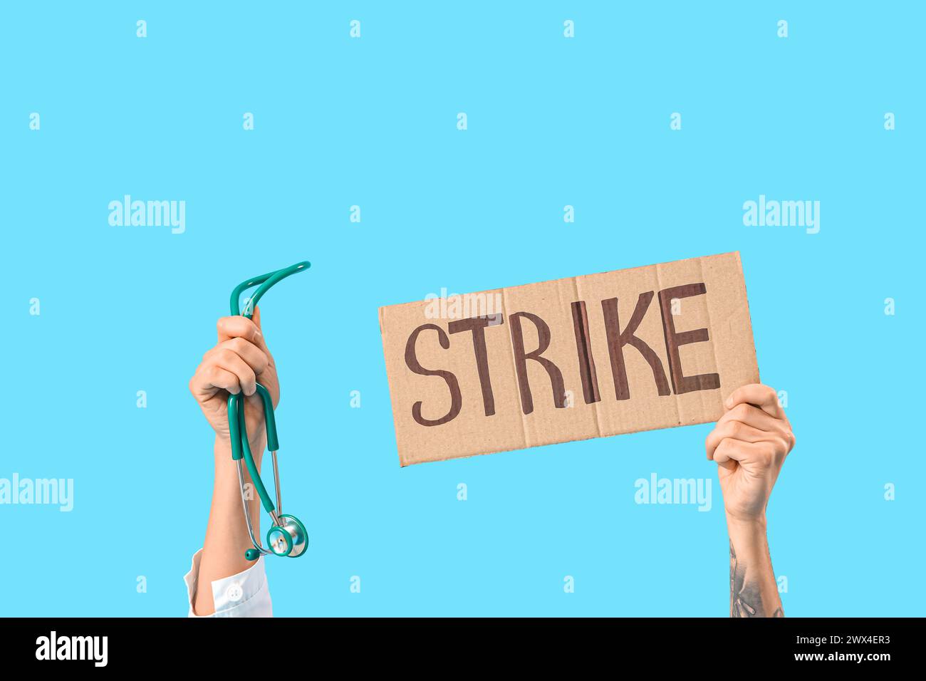 Protesting male doctor holding placard with word STRIKE and stethoscope ...