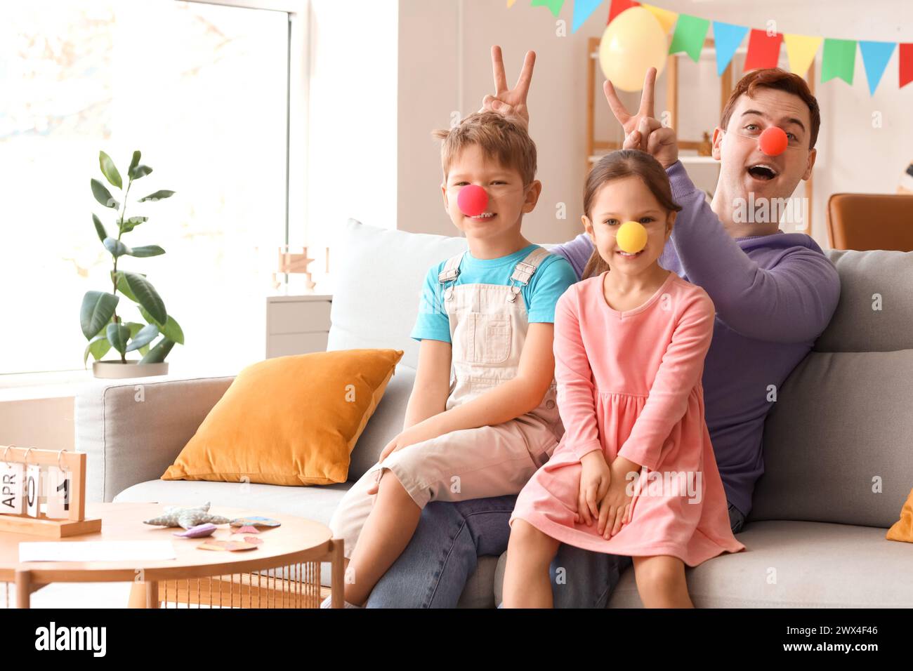 Father and his children with clown noses at home. April Fool's Day ...