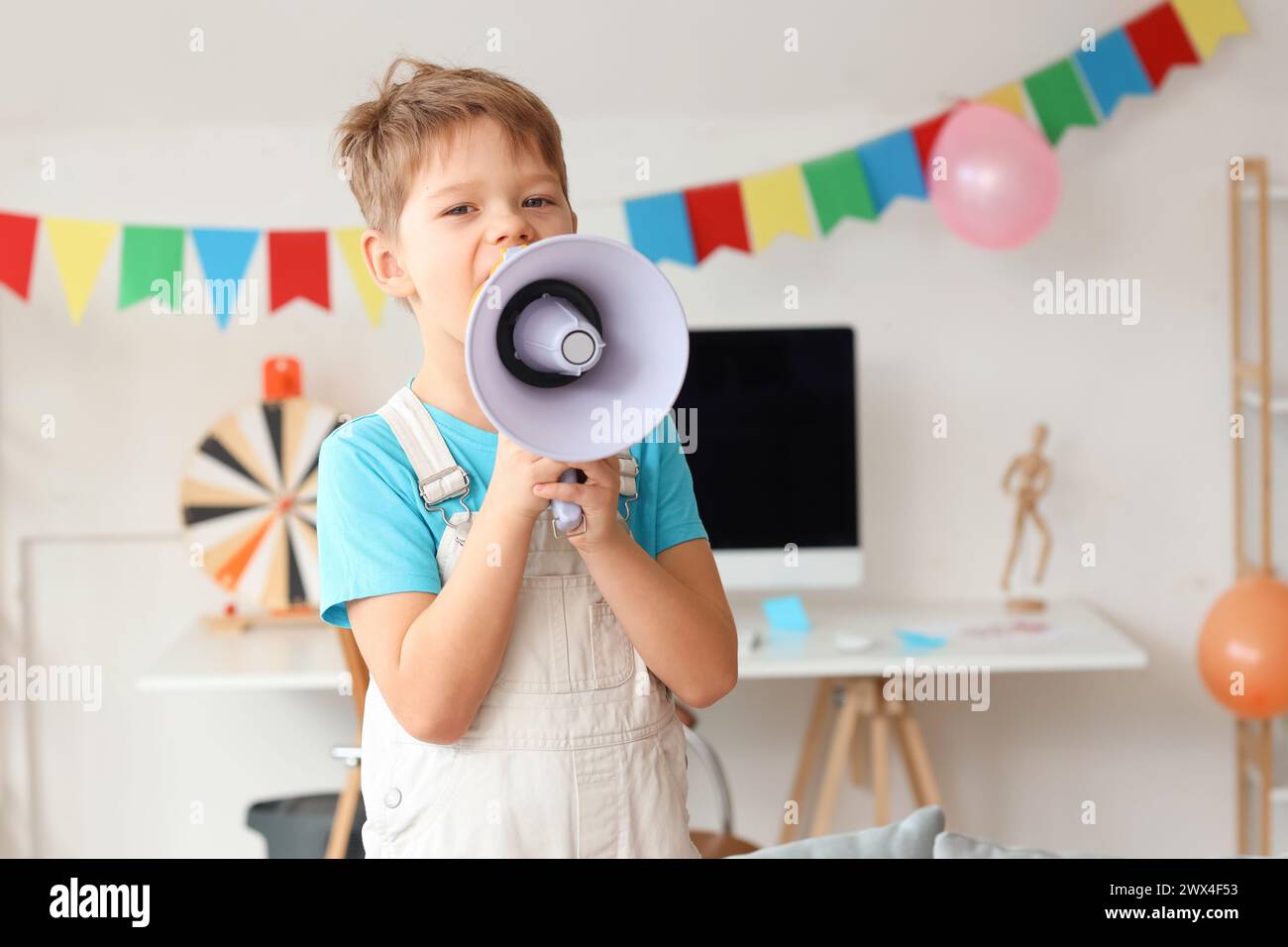 Cute little with megaphone at home. April Fool's Day prank Stock Photo ...