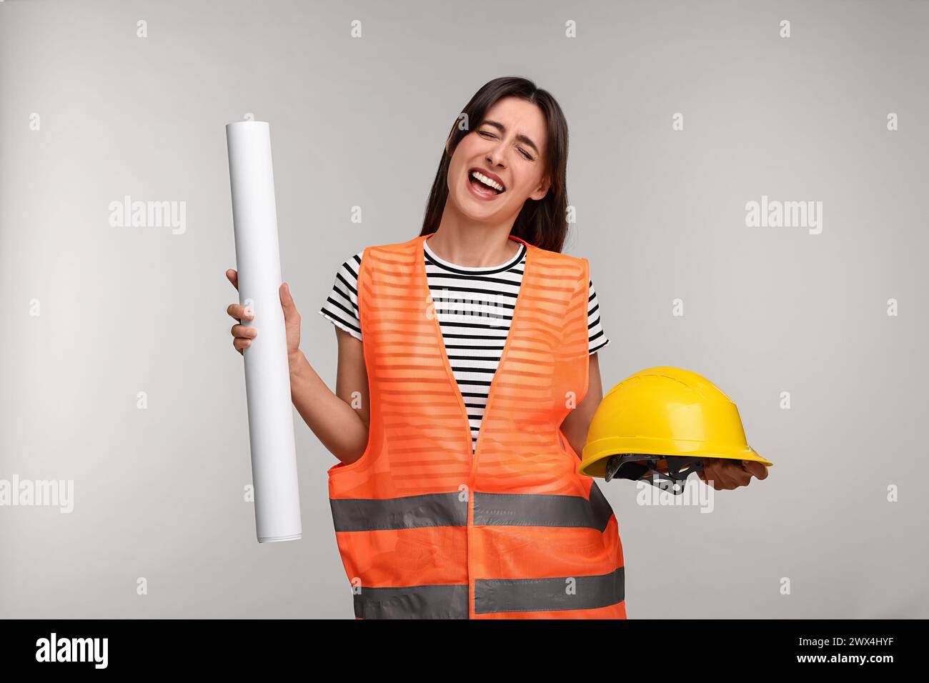 Architect with hard hat and draft on light grey background Stock Photo ...