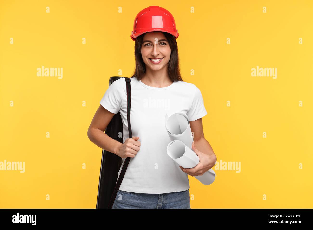 Architect in hard hat with drafts and tube on yellow background Stock ...