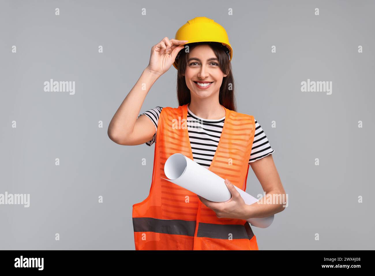 Architect in hard hat with draft on light grey background Stock Photo ...