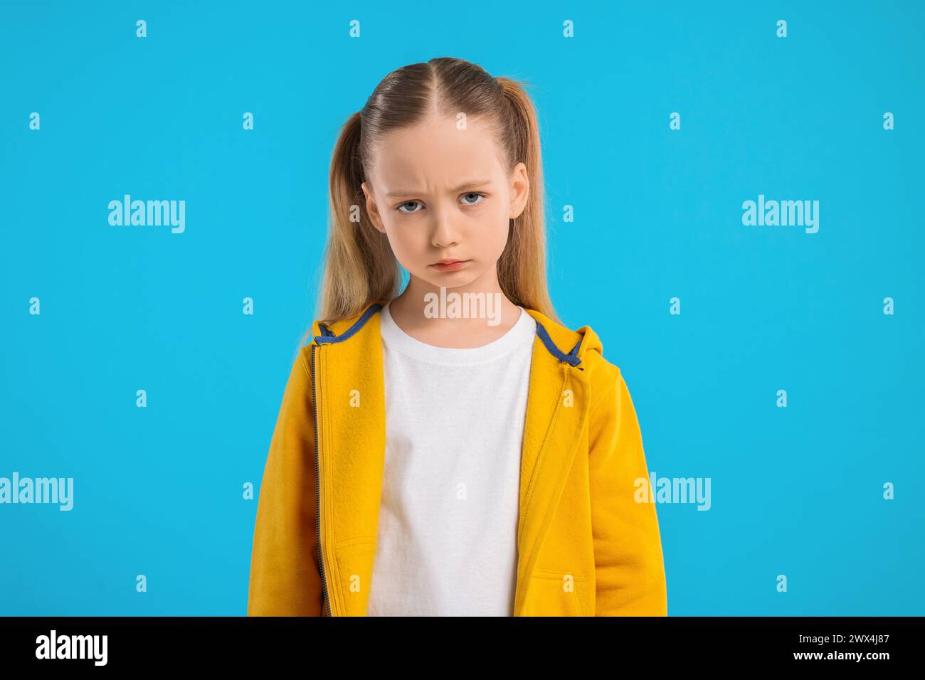 Portrait of sad girl on light blue background Stock Photo - Alamy