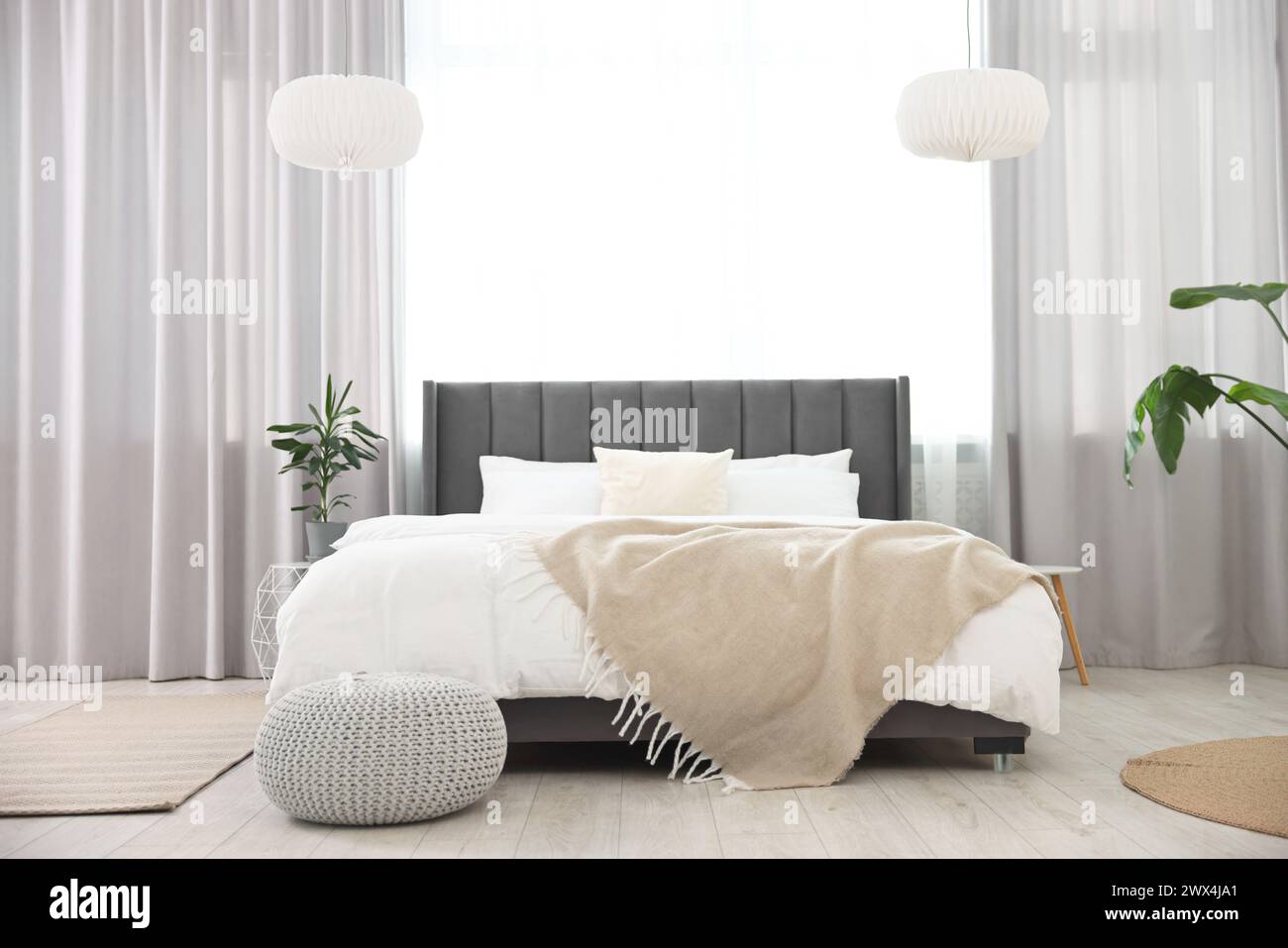 Soft beige plaid on bed in stylish bedroom. Interior design Stock Photo ...