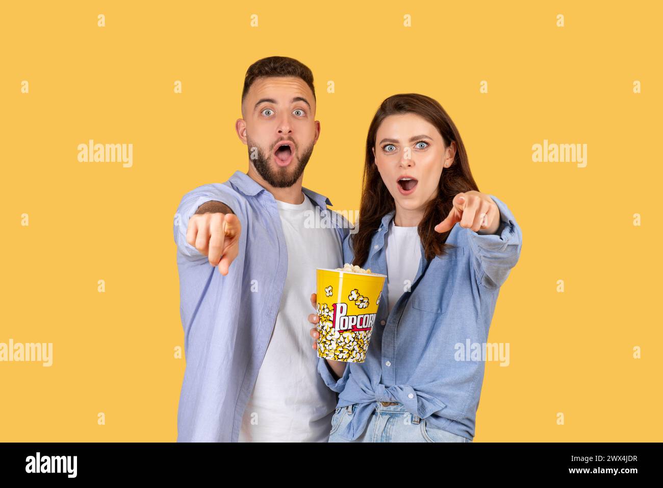 Two people shocked watching with popcorn Stock Photo - Alamy