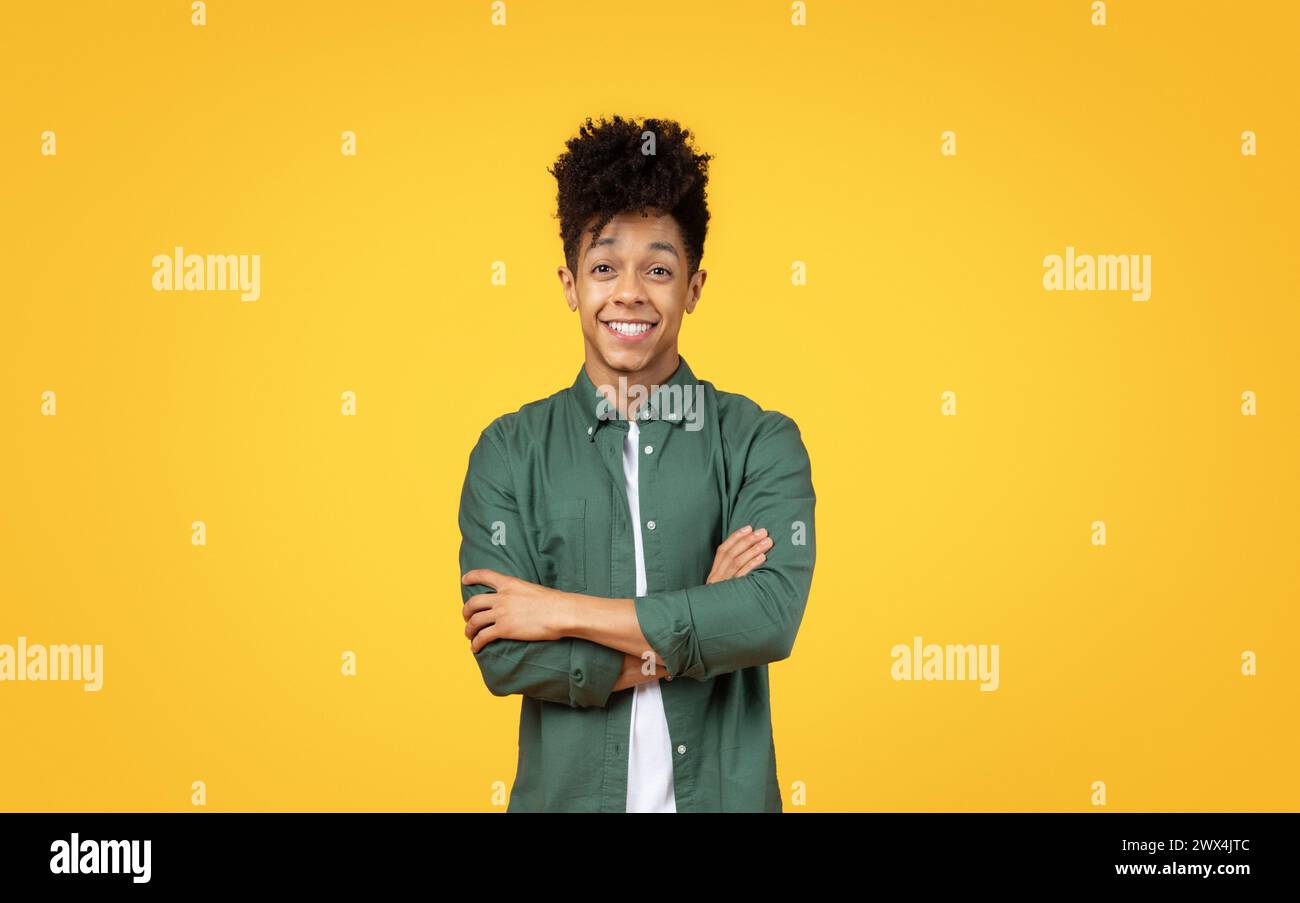 Young man with arms crossed smiling Stock Photo - Alamy