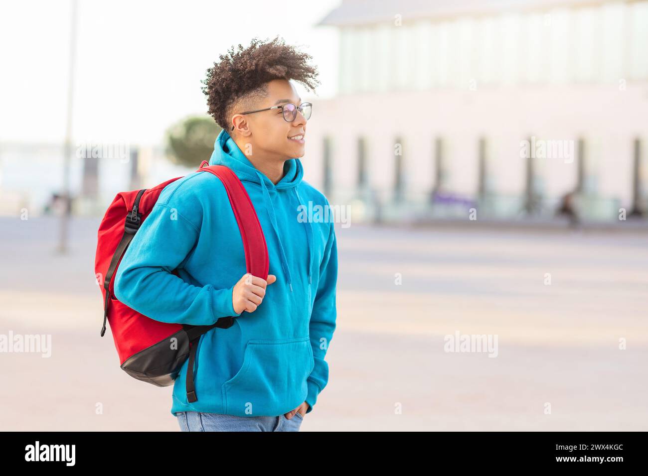 Student walking with backpack and looking away Stock Photo - Alamy