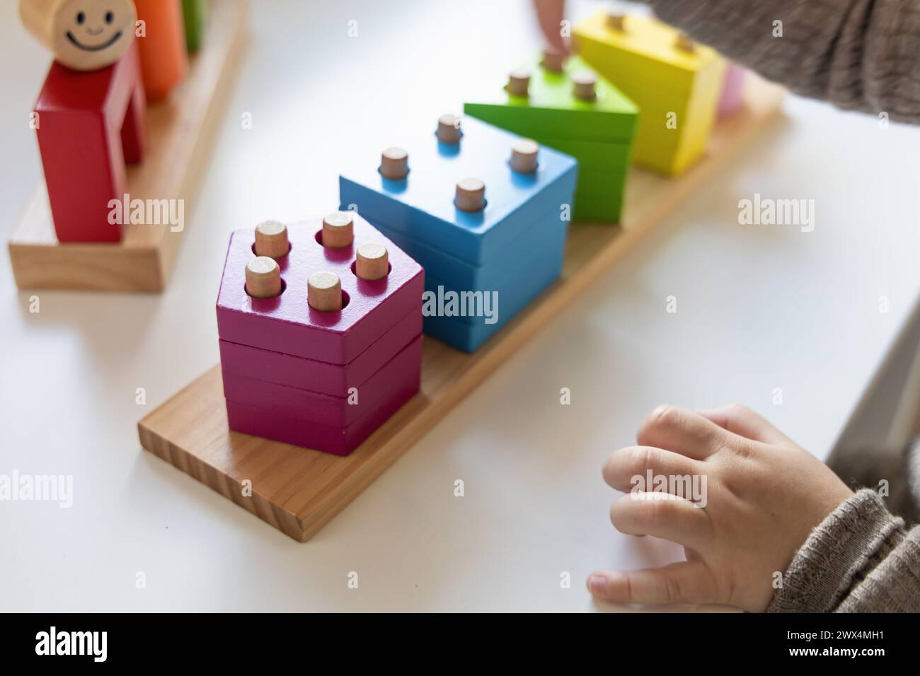 Child playing a fun-filled game of logic with colourful wooden blocks ...