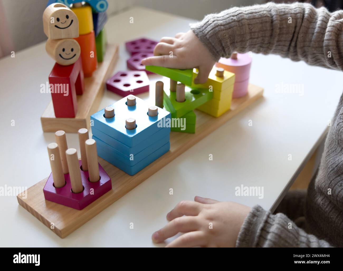 Child playing a fun-filled game of logic with colourful wooden blocks ...