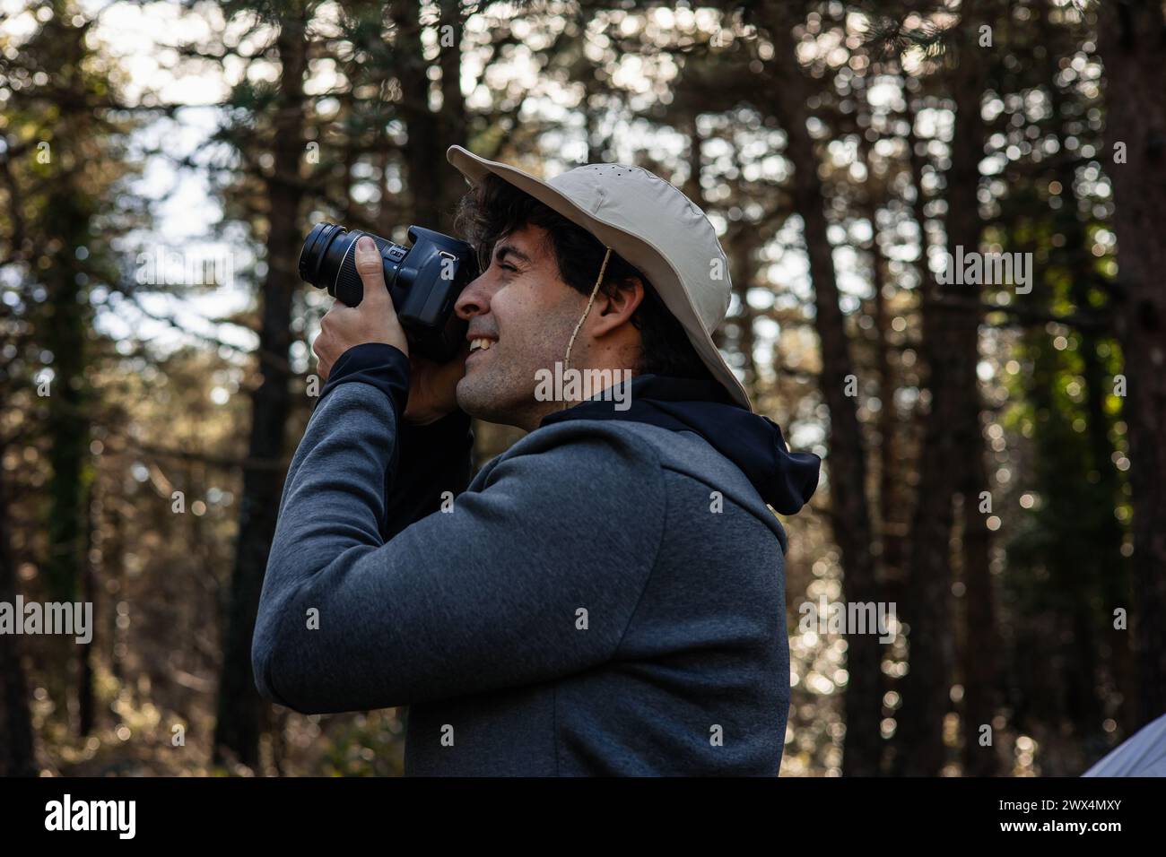 closeup A nature photographer, wearing an explorer's hat, is seen in ...